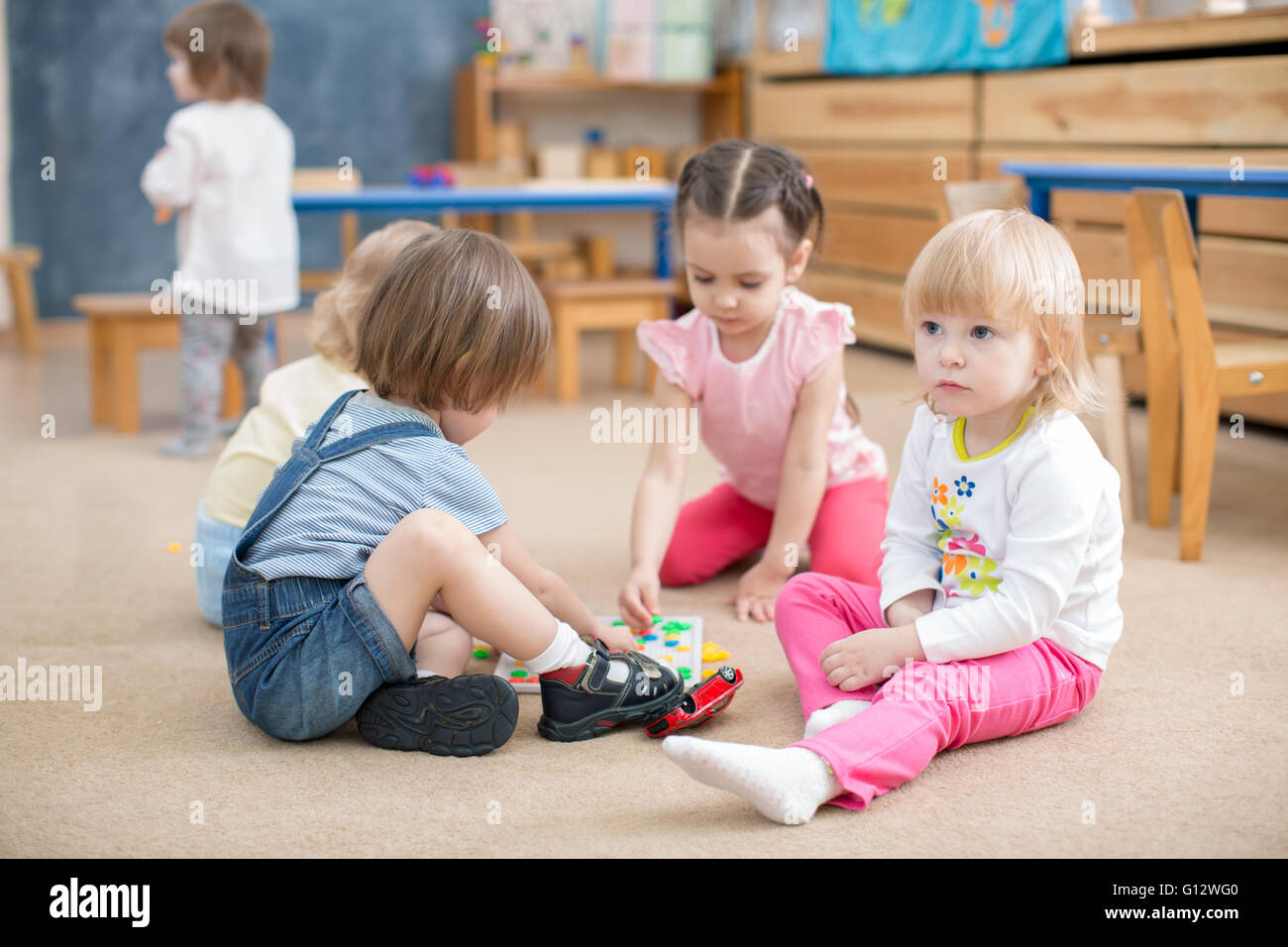 children playing games in kindergarten playroom Stock Photo - Alamy