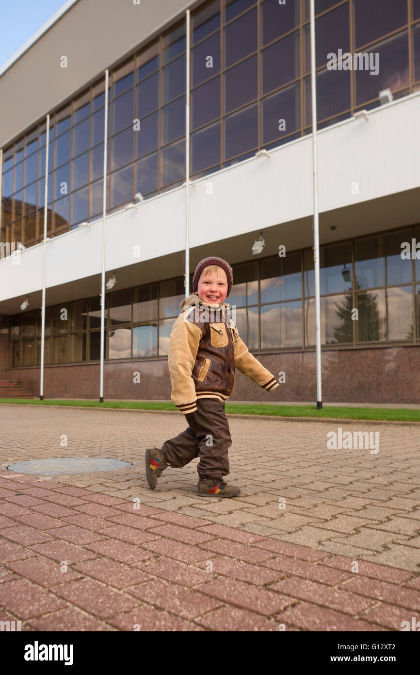 Little boy sitting in front of big window in the city, outdoors Stock ...