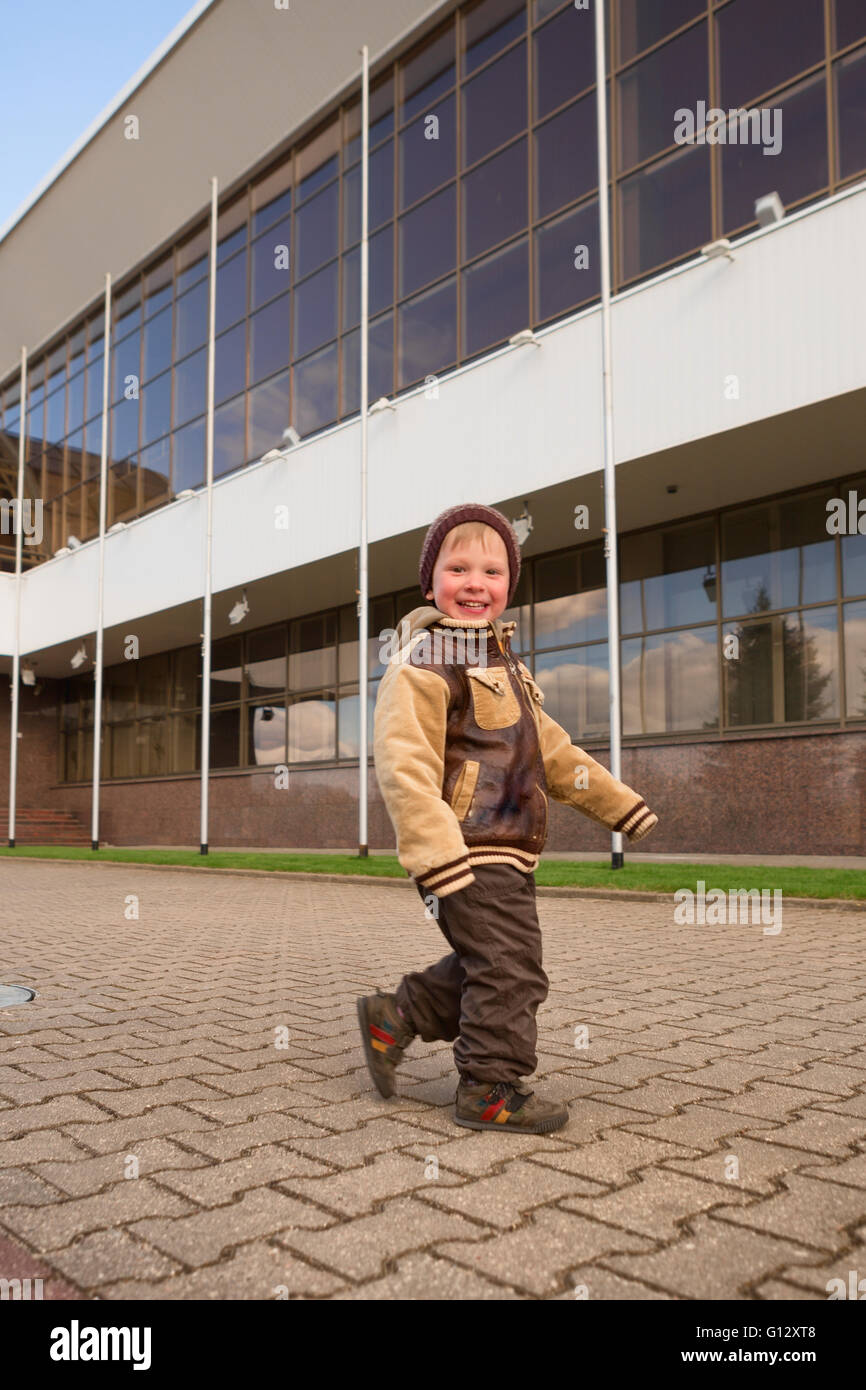 Little boy sitting in front of big window in the city, outdoors Stock ...