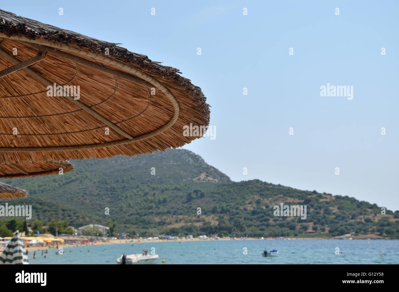 Straw parasol on a beach in summer time Stock Photo - Alamy