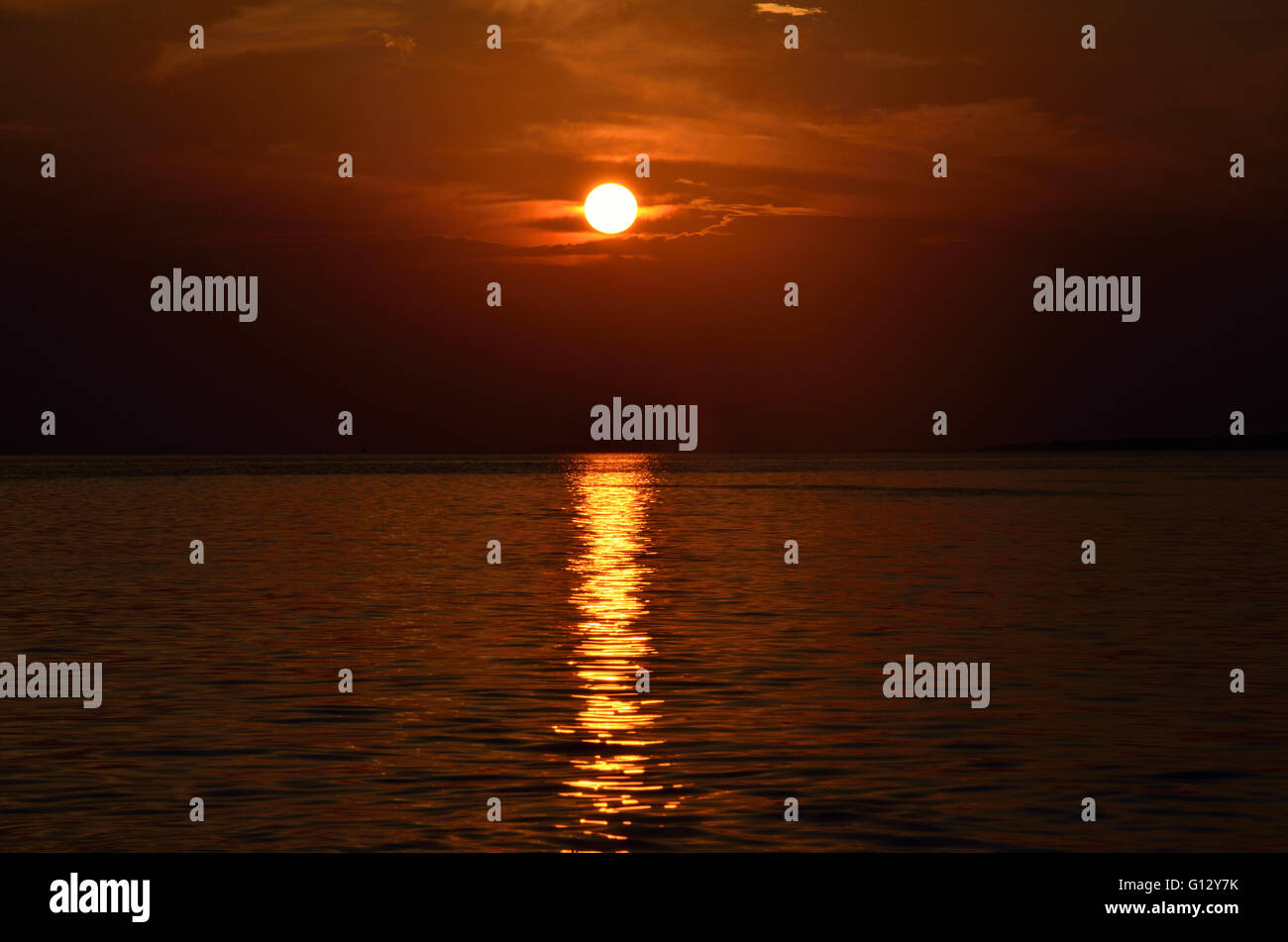 Sun is setting above the sea leaving long reflection on water Stock ...