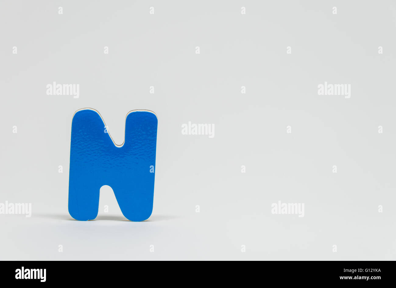 Blue wooden alphabet N with white background and selective focus Stock ...