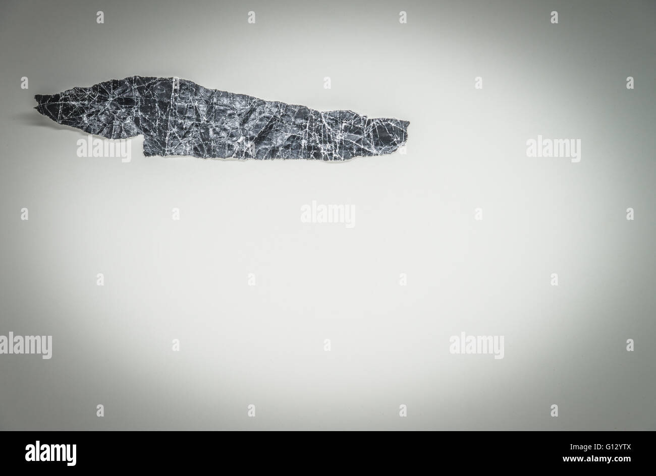 Piece of Crumpled and torned black paper with selective focus and under ...