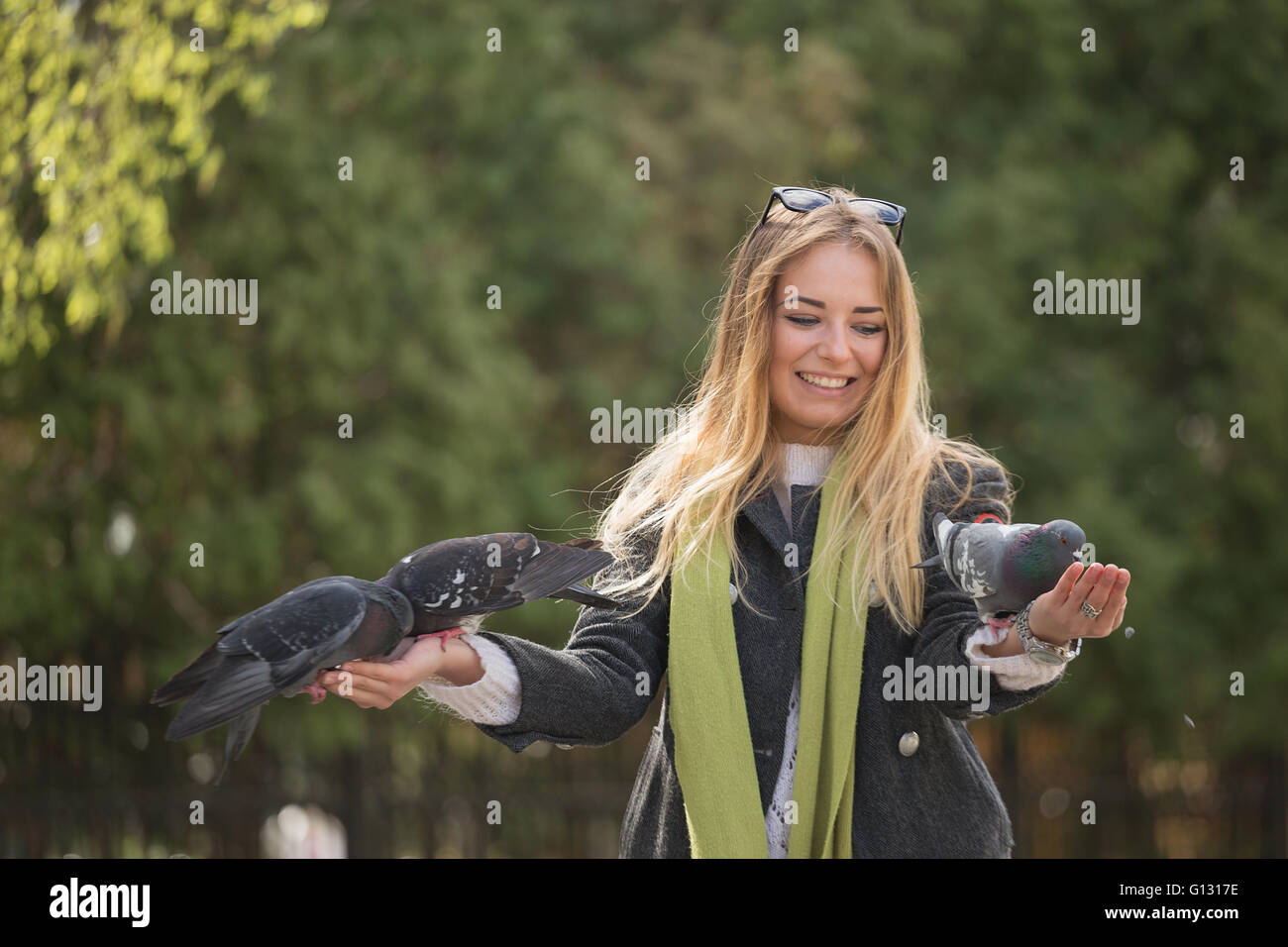 photo of Girl and doves. feeding pigeons in the park Stock Photo - Alamy