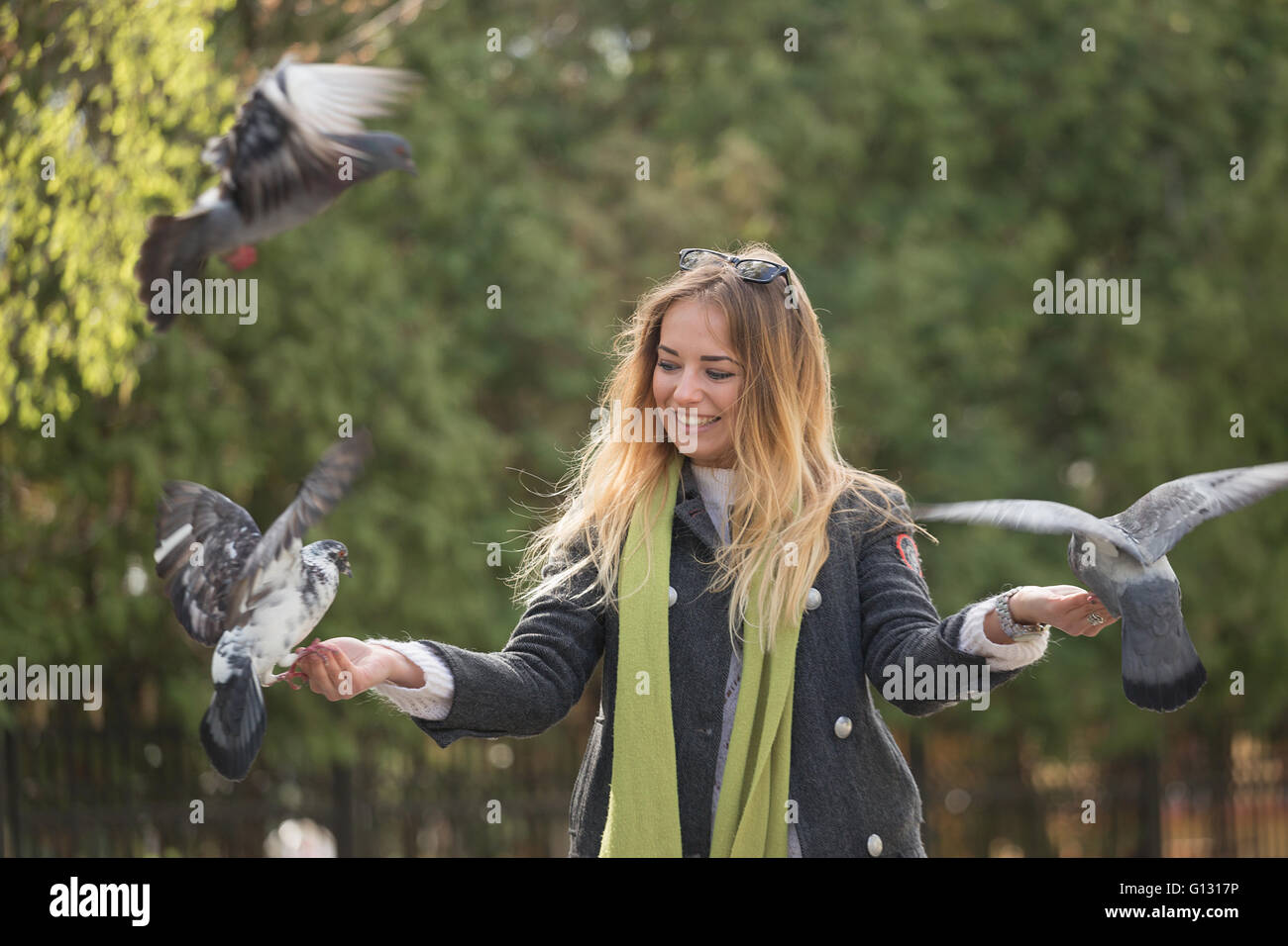 photo of Girl and doves. feeding pigeons in the park Stock Photo - Alamy