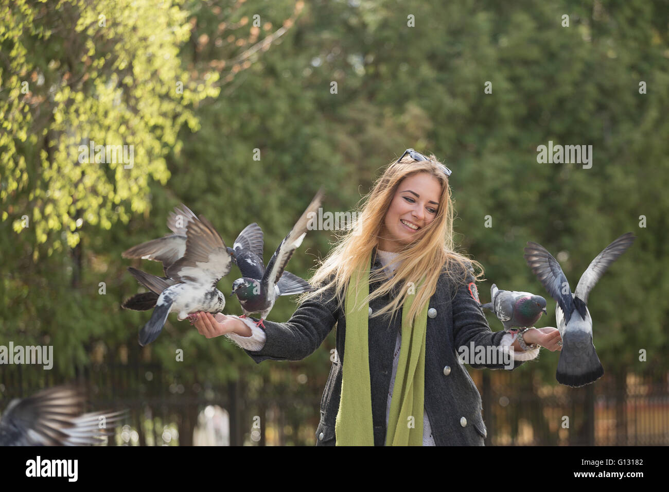 photo of Girl and doves. feeding pigeons in the park Stock Photo - Alamy