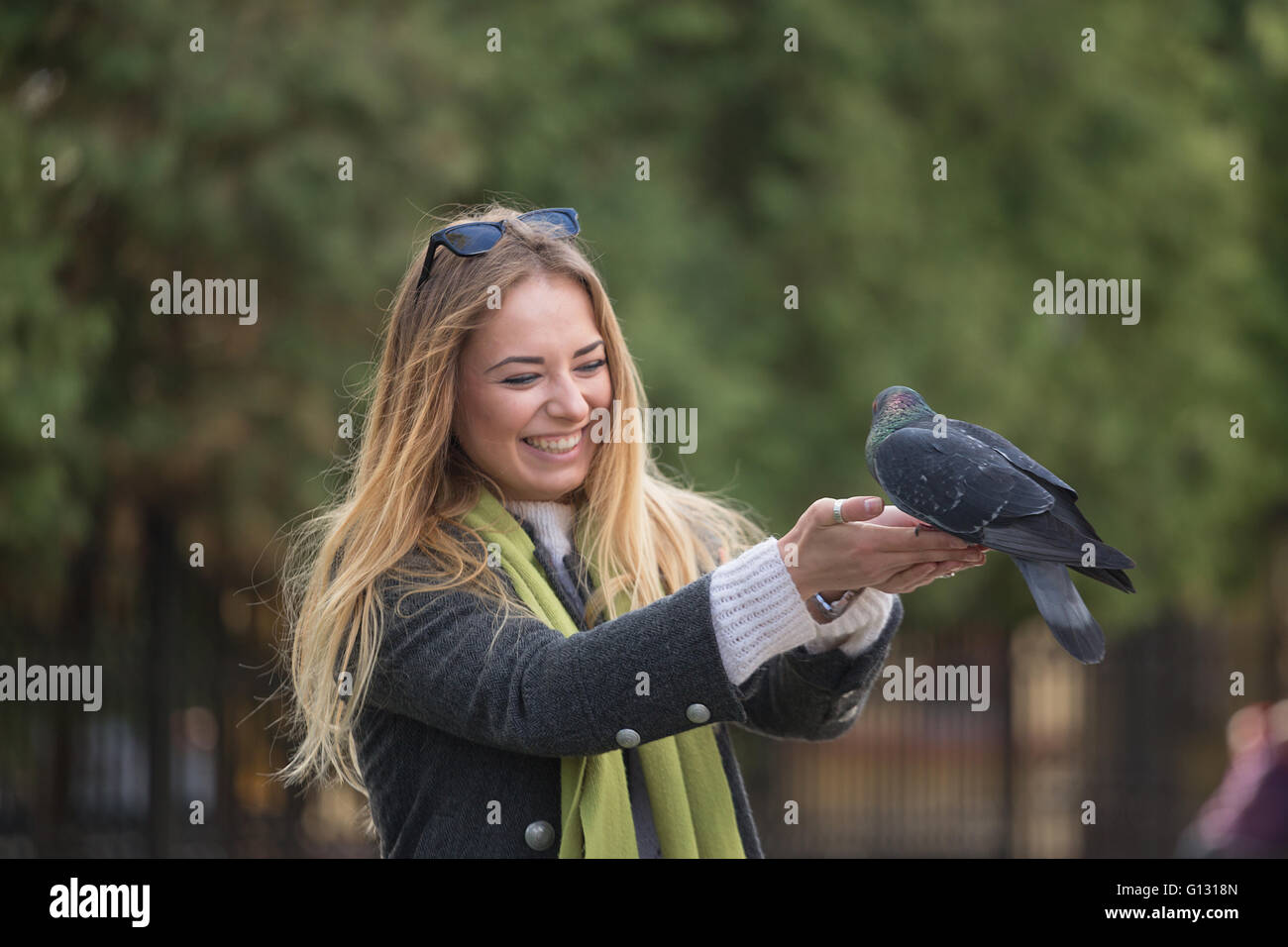 photo of Girl and doves. feeding pigeons in the park Stock Photo - Alamy
