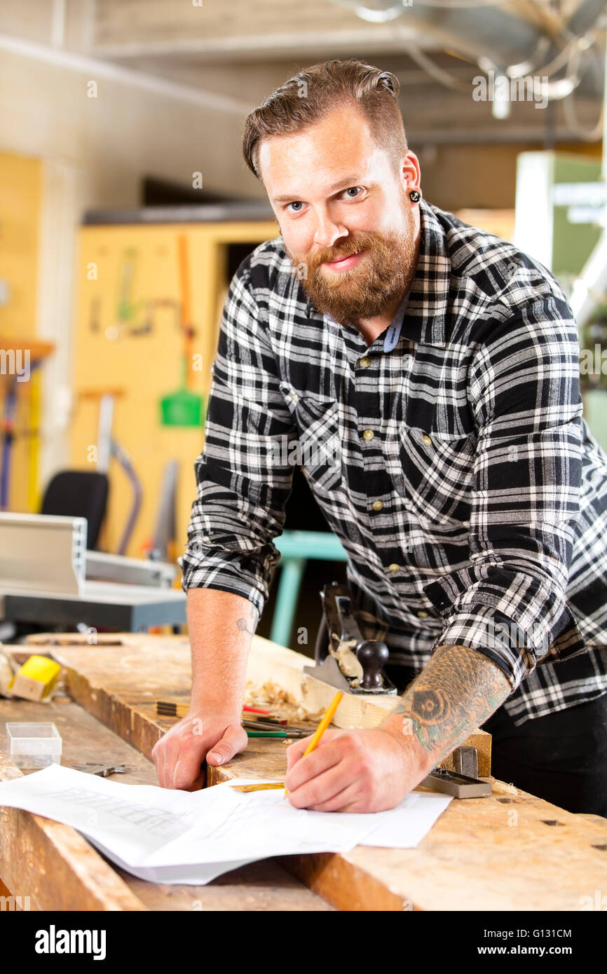 Smiling carpenter planning work in the workshop Stock Photo - Alamy