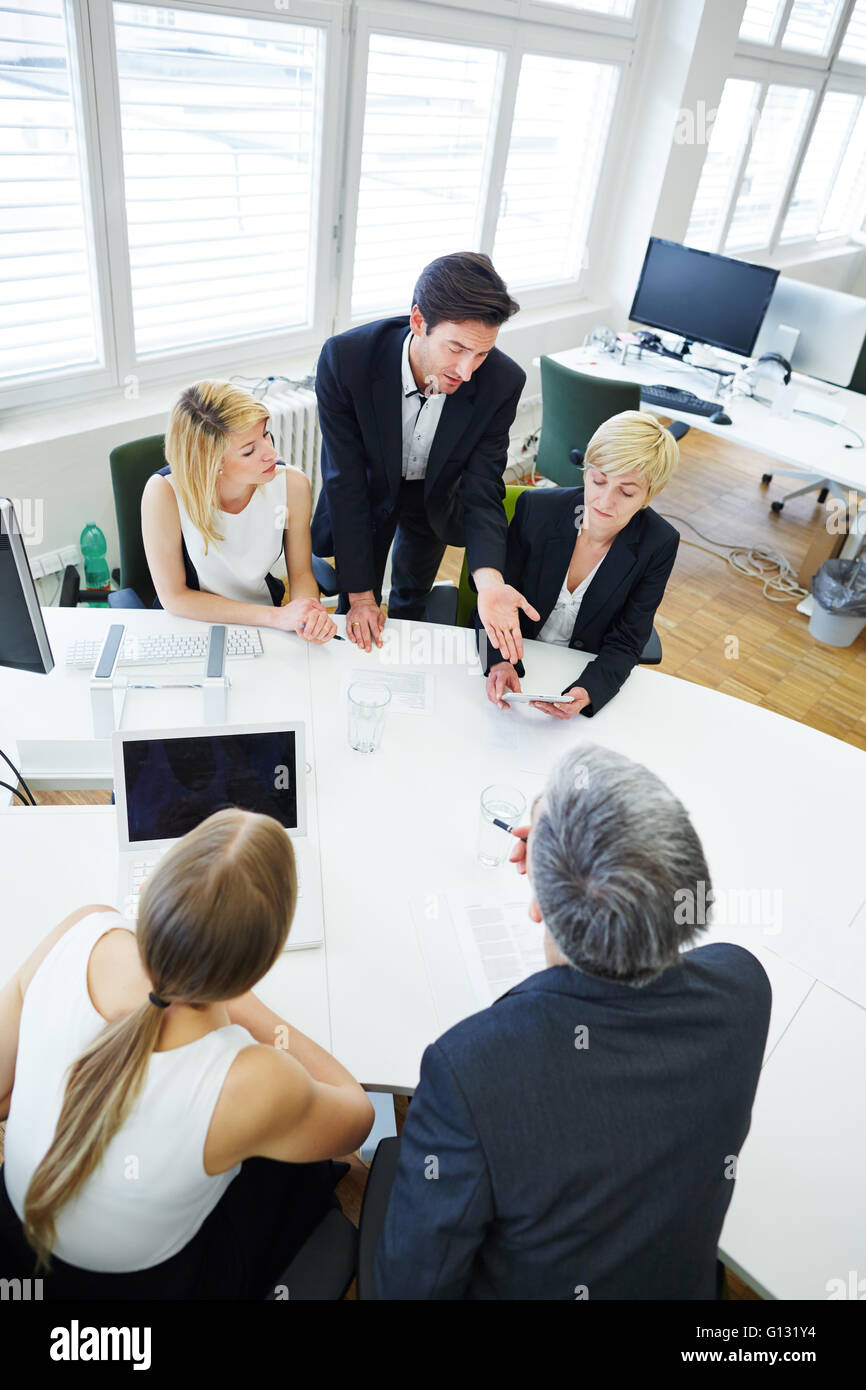 Team talking in business meeting at conference table about future ...