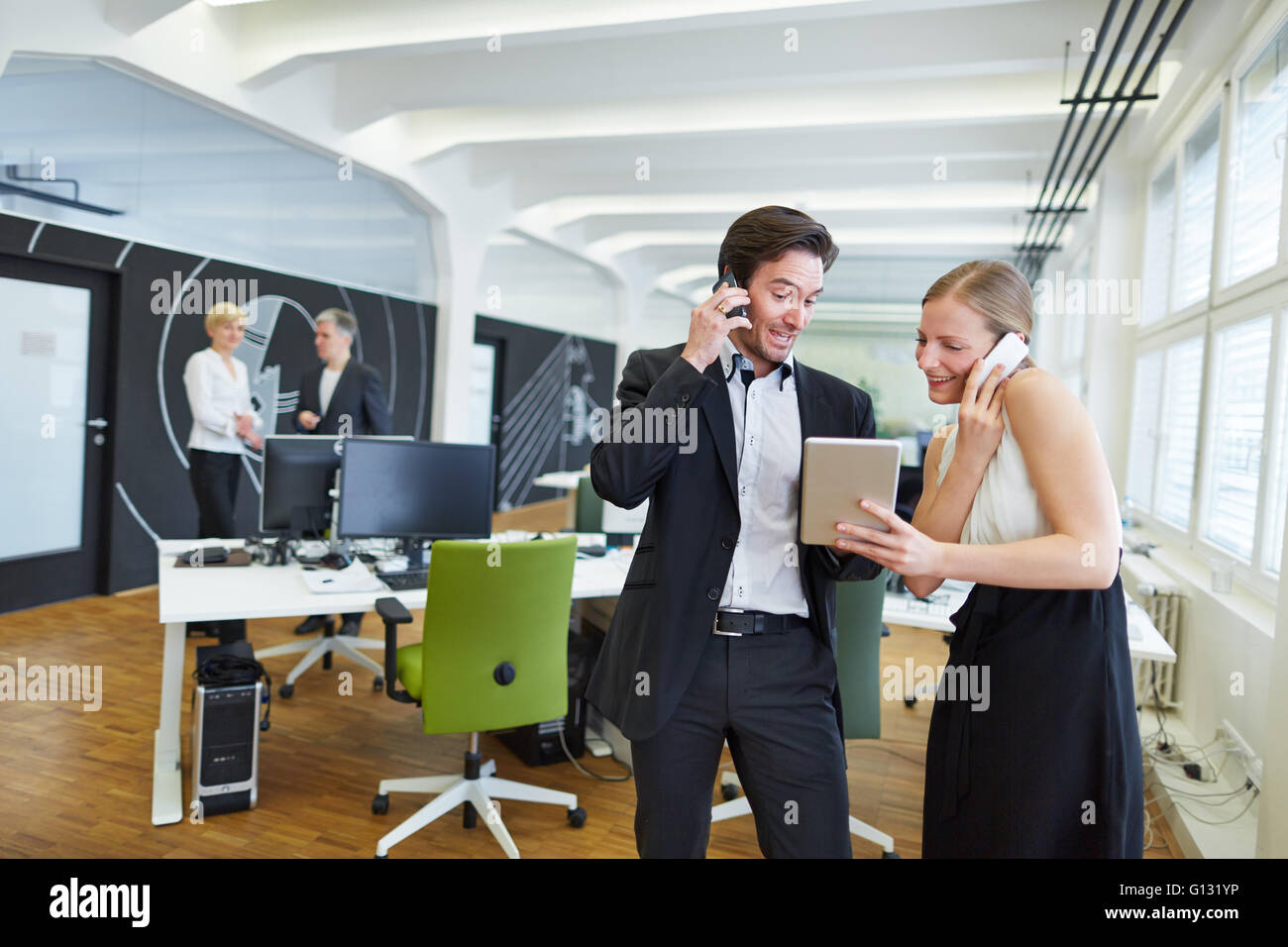 Woman and making making phone calls in office and looking at tablet PC ...