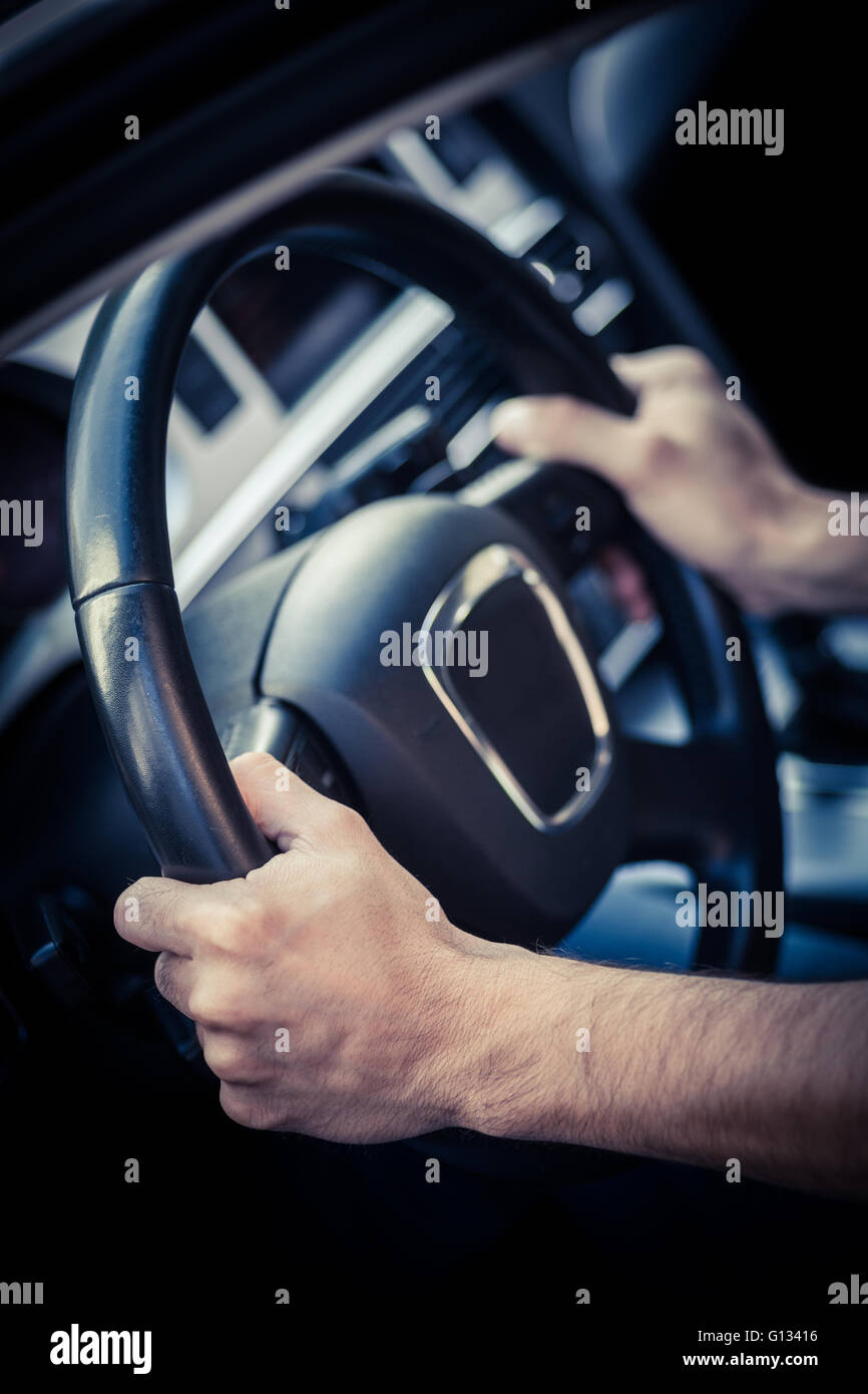 Color image of two hands holding a steering wheel inside a car Stock ...