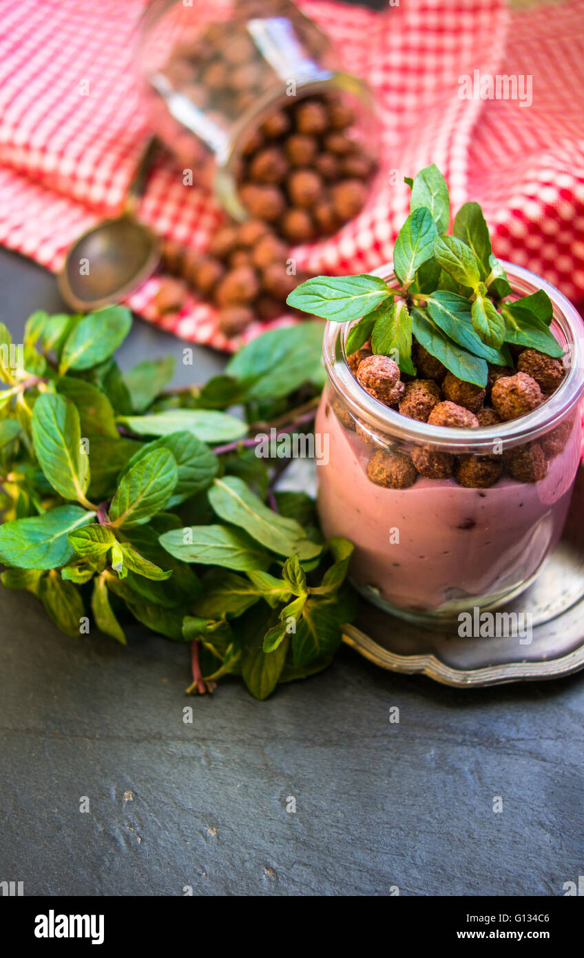 Chocolate breakast flakes with yogurt and mint in vintage glass on ...