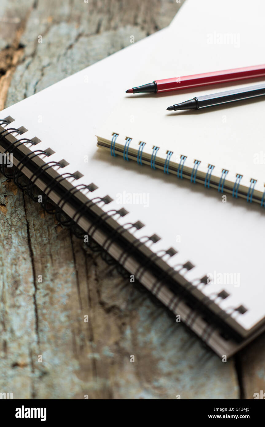 Notepads and pens on old rustic wooden board Stock Photo - Alamy