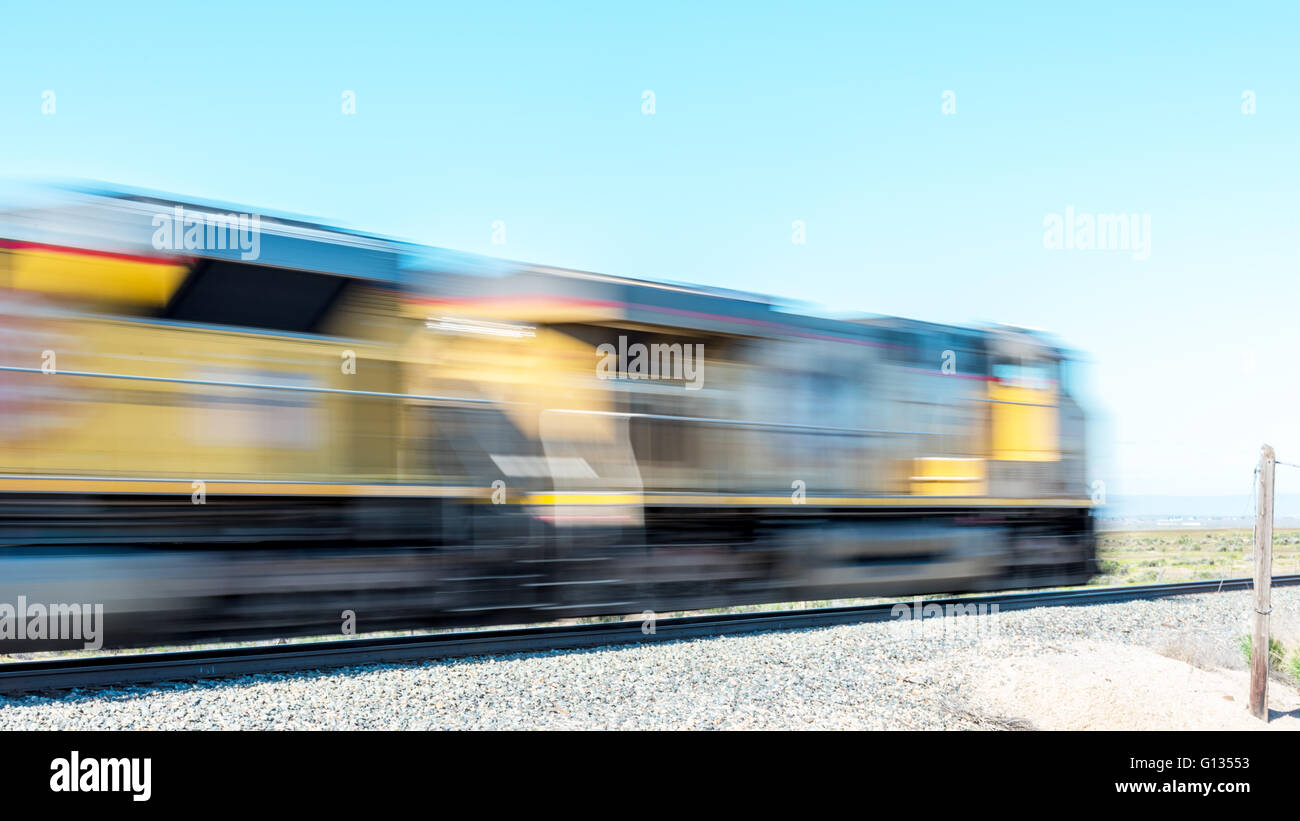 Train races past with a blur along the tracks Stock Photo - Alamy