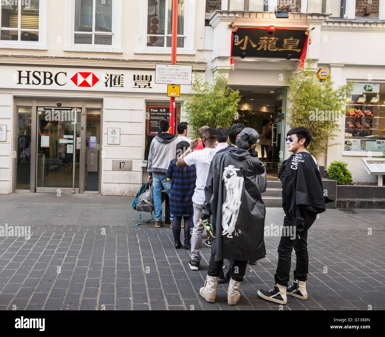 People queuing outside the HSBC cash point machine on Gerrard Street ...