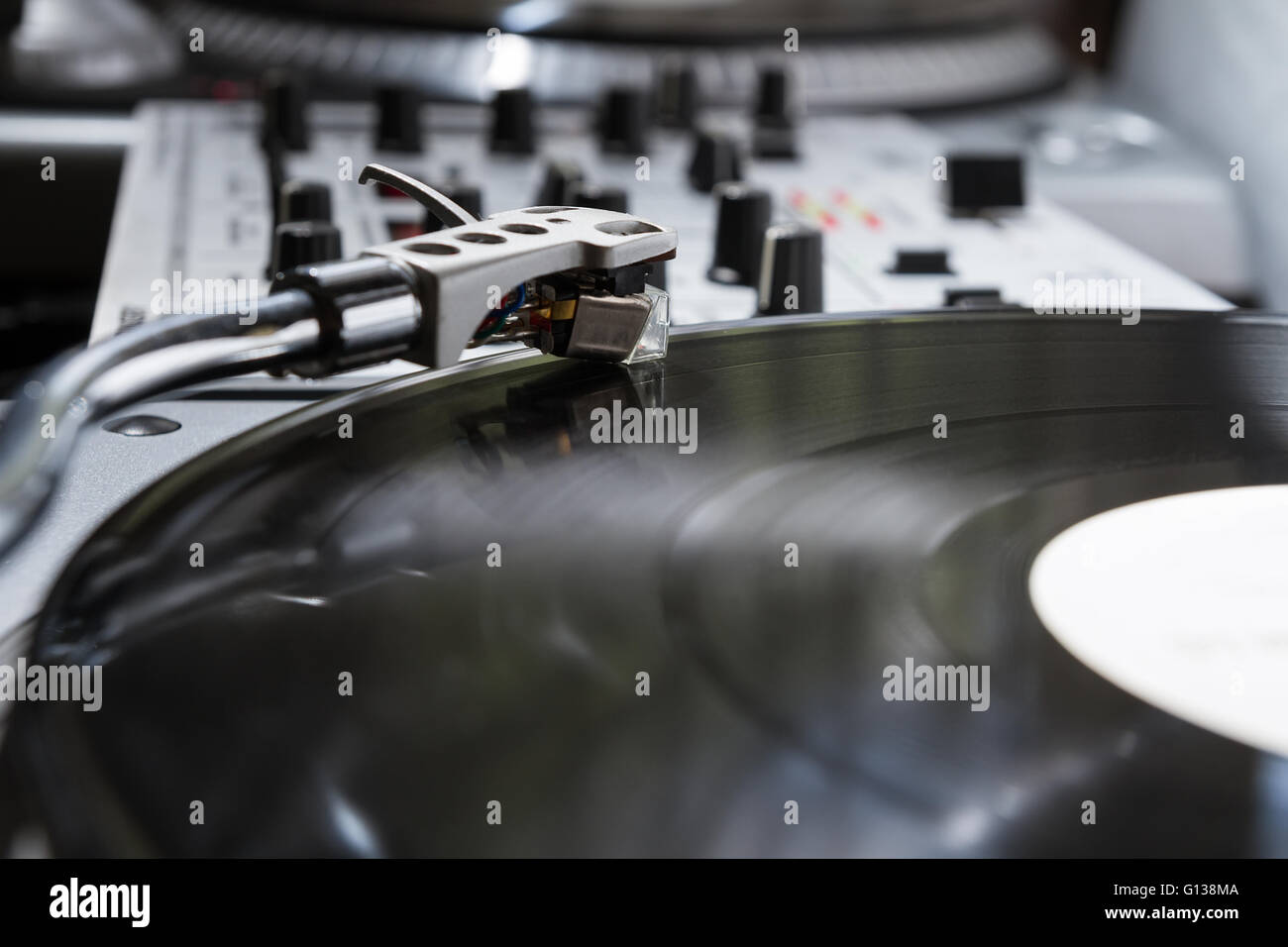 Turntable playing analog audio vinyl disc with music. Close up on ...