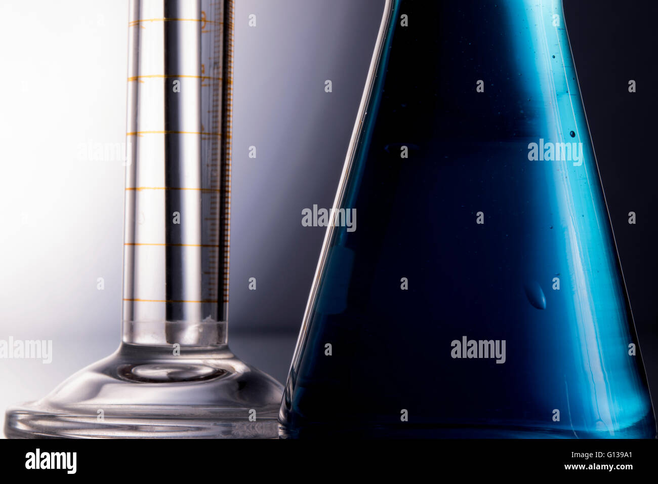 Blue chemistry in Erlenmeyer flask with graduated cylinder Stock Photo ...