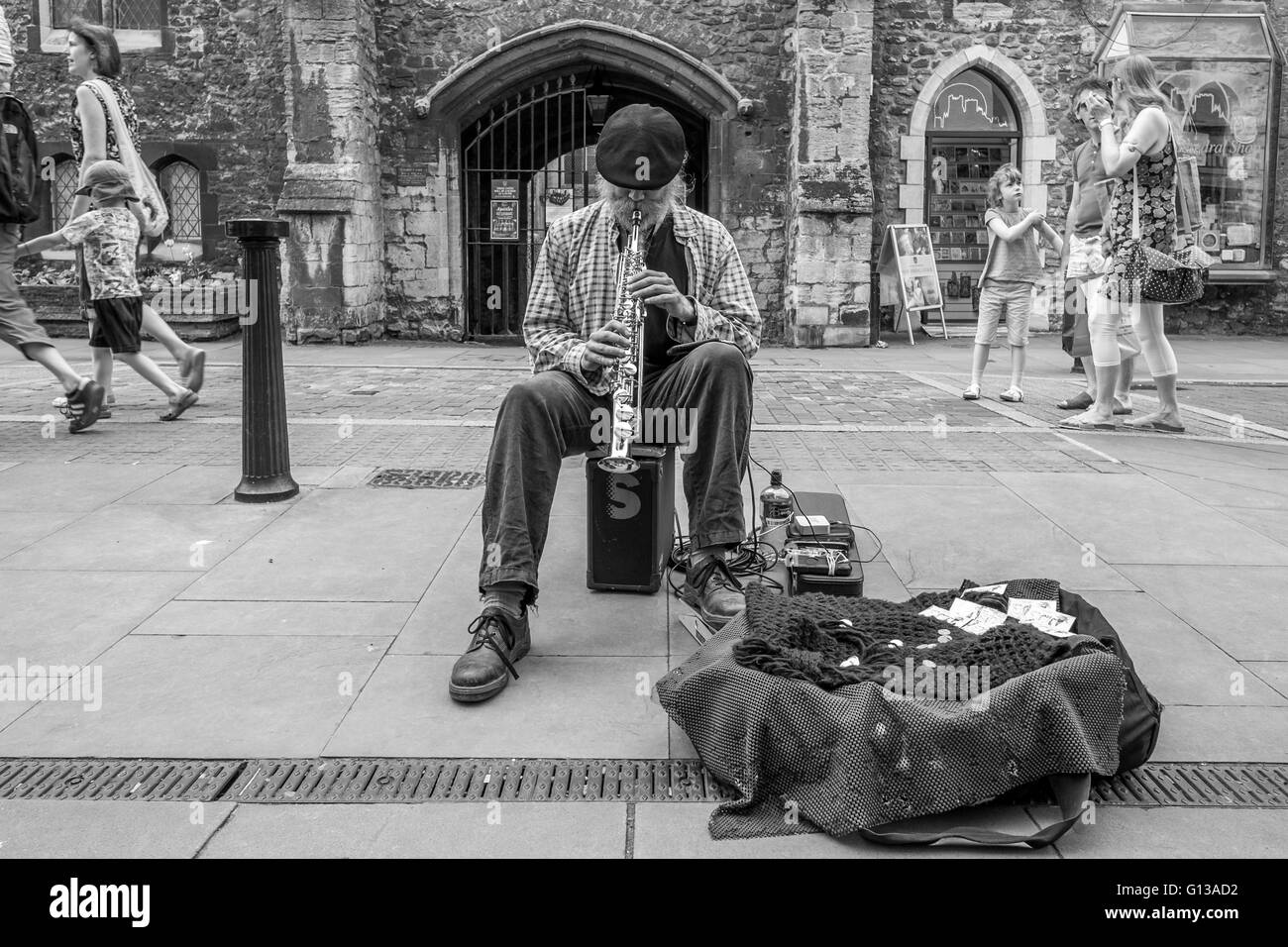 A street musician Roscoe plays saxophone busking on the high street of ...