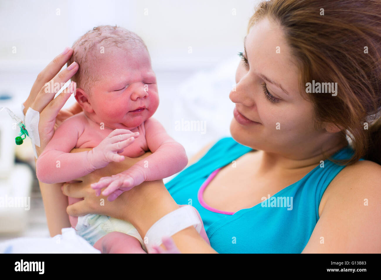 Mother giving birth to a baby. Newborn baby in delivery room. Mom ...
