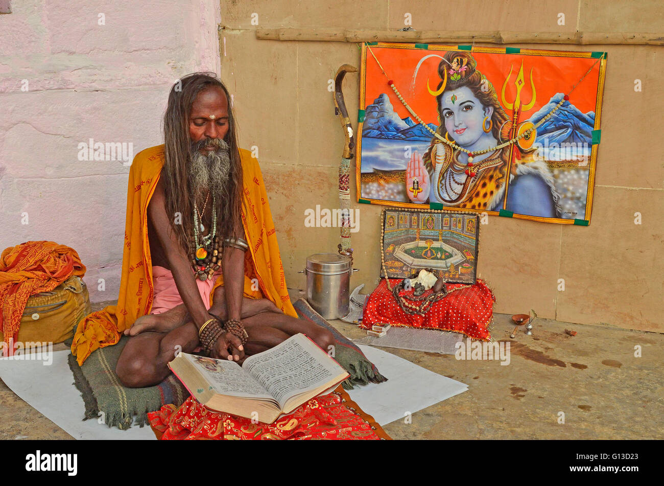 A Sadhu or Hindu saint reading the holy Gita with an image of Lord ...