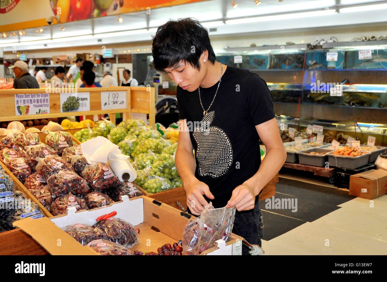 New York City: Worker bagging fresh grapes at the Jmart Asian ...