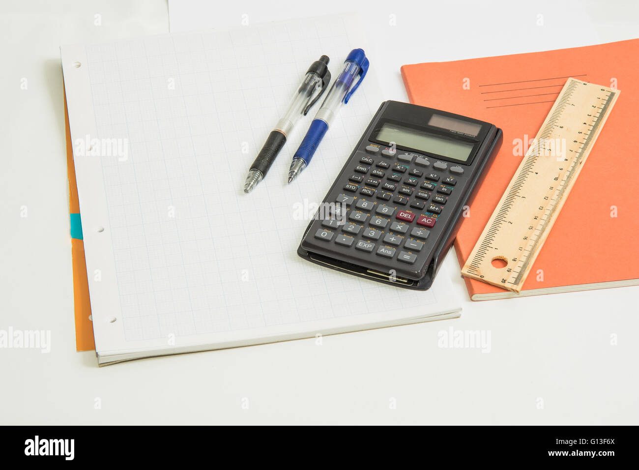 The concept of learning shown with a calculator & pens on a background ...