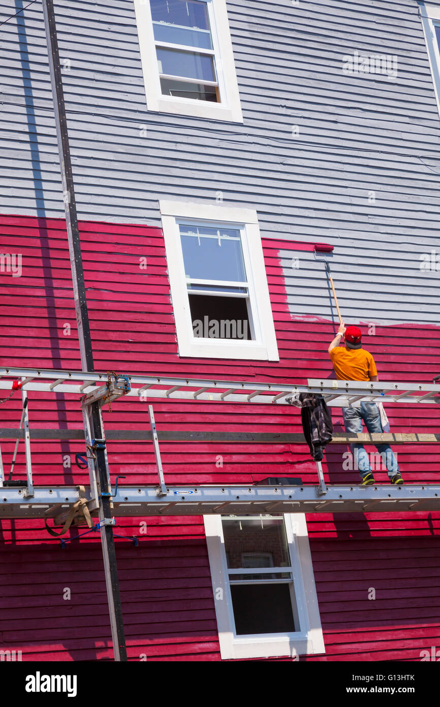 A painter painting a corner row house (Jellybean Row) in downtown St ...