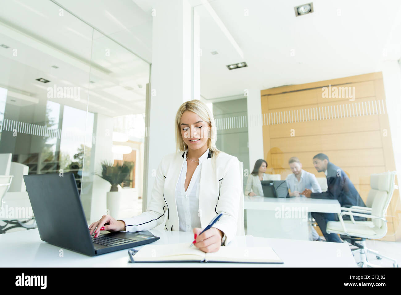 Pretty young blond woman working in the mdoern office Stock Photo - Alamy