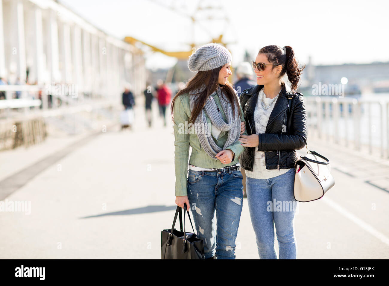 Two women walking together on the street Stock Photo - Alamy