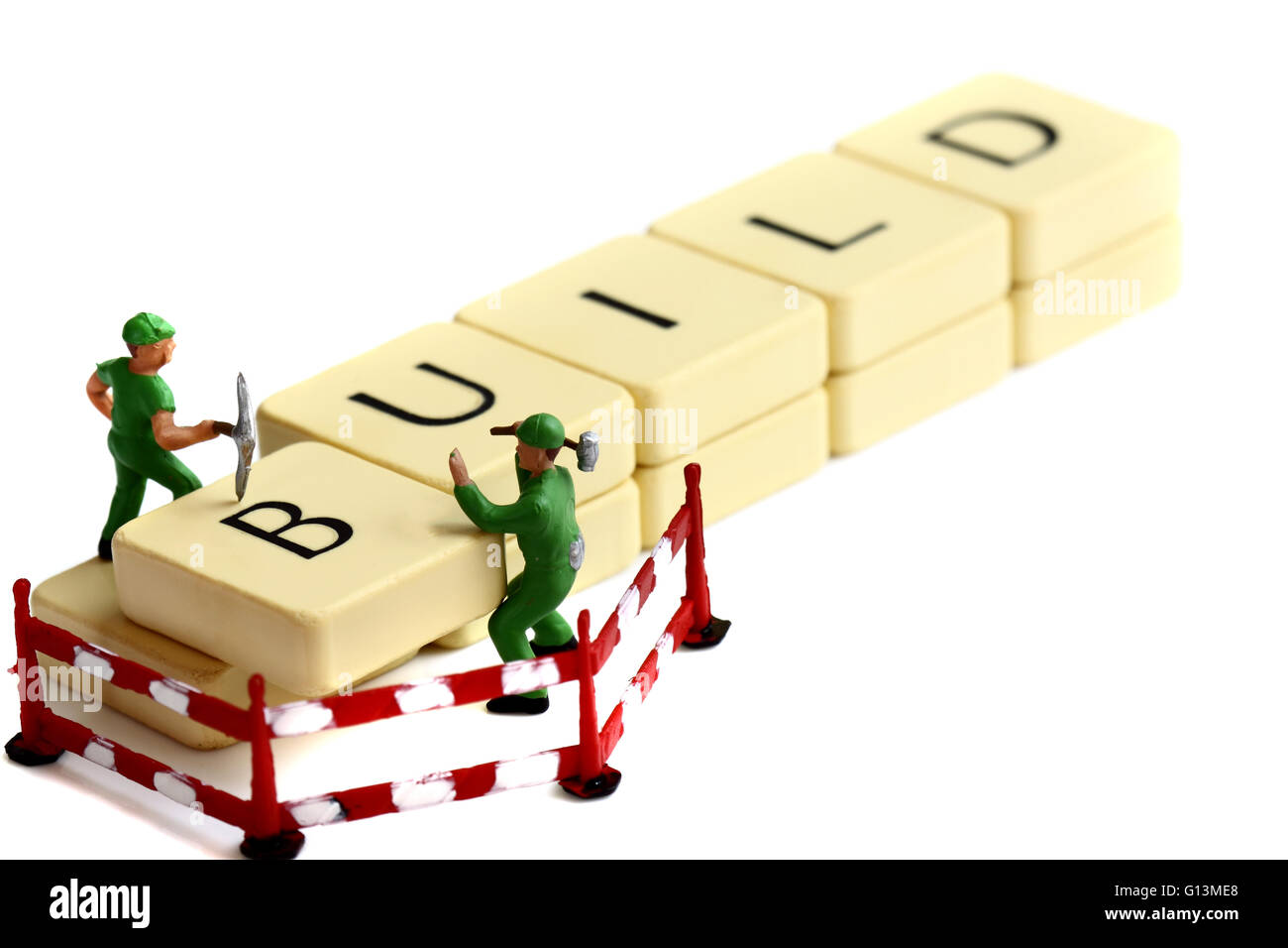 Miniature builders stacking tiles to make the word build Stock Photo ...