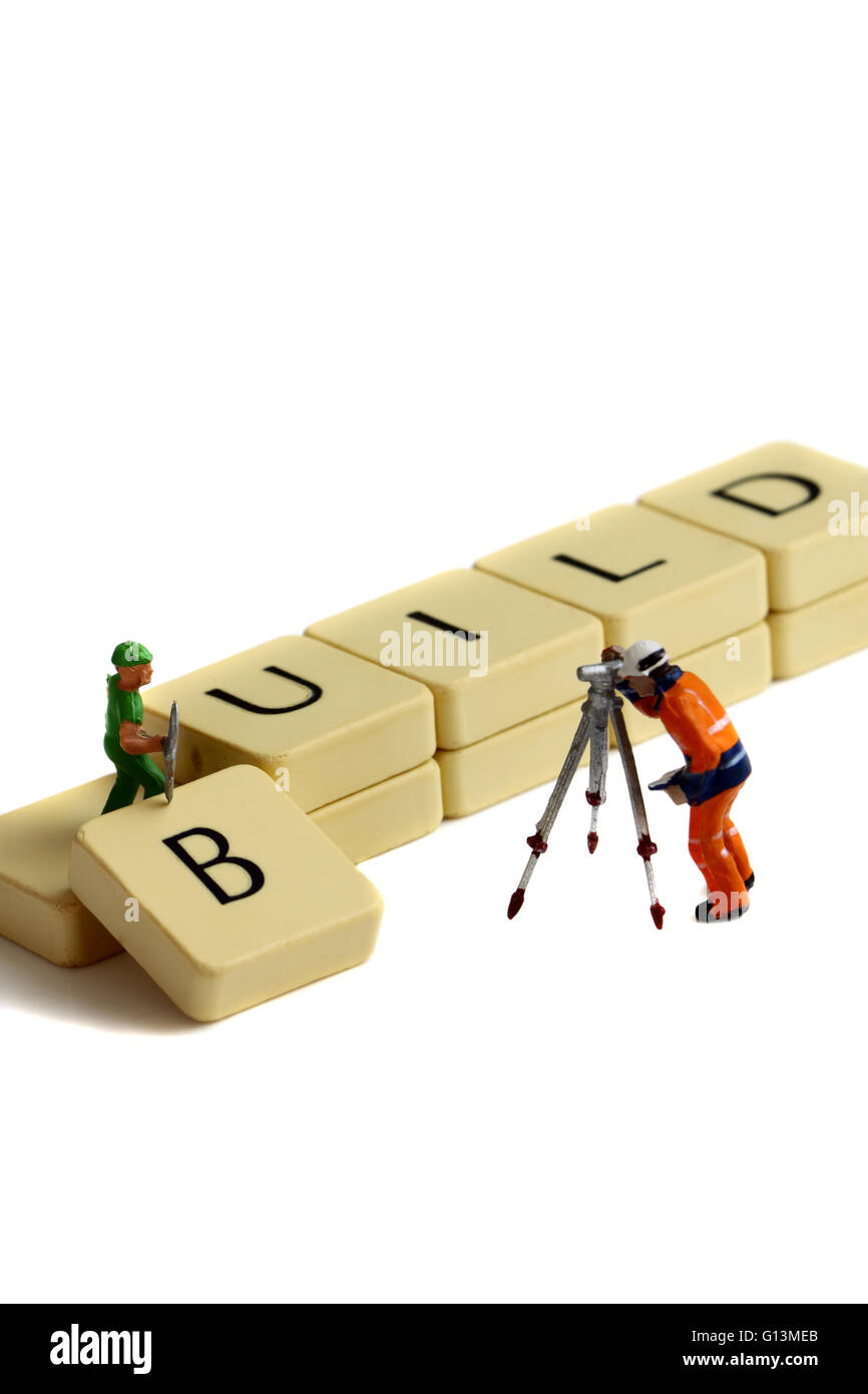 Miniature builders stacking tiles to make the word build Stock Photo ...