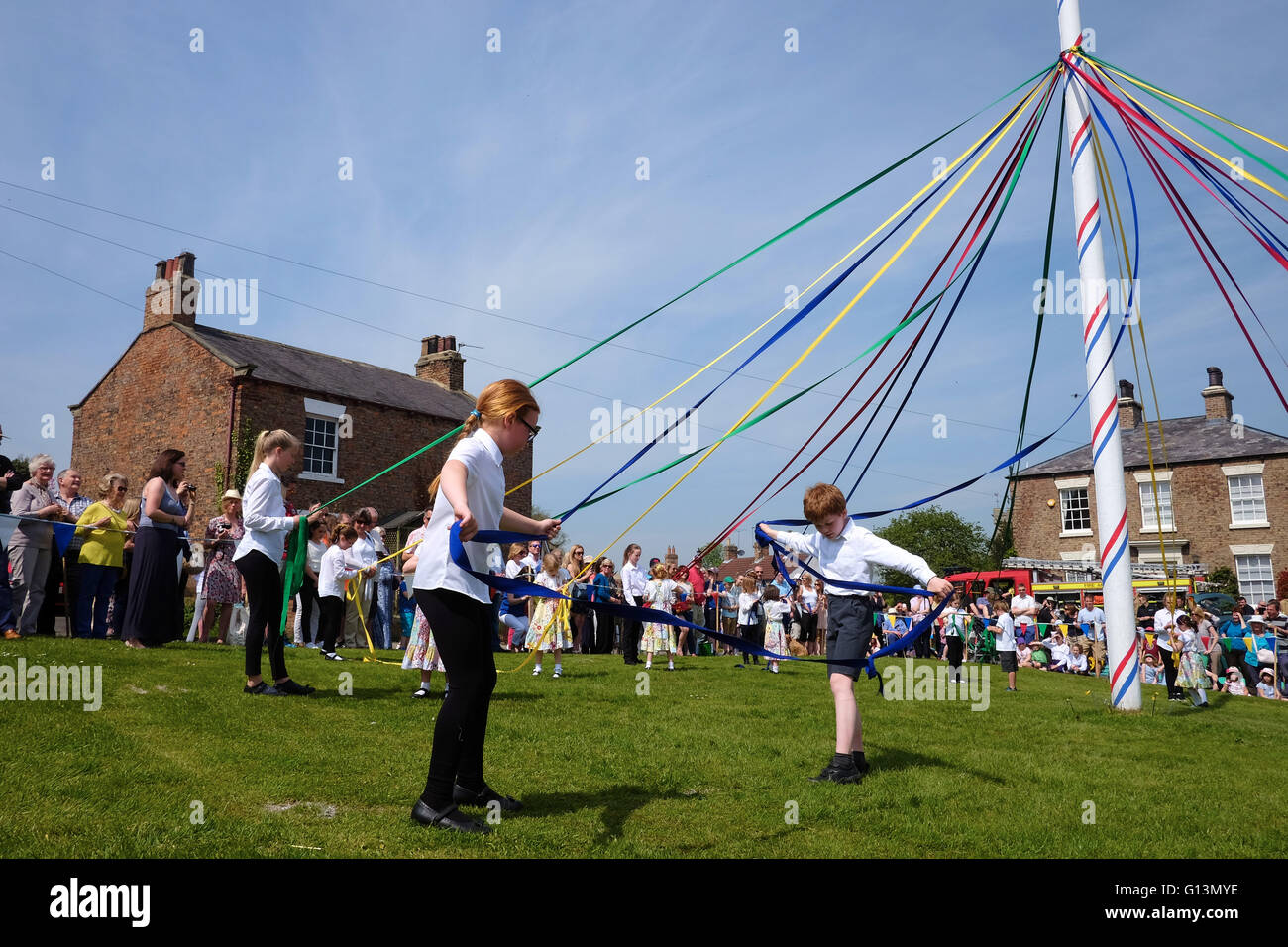 Children prepare the ribbons before dancing around the maypole in ...