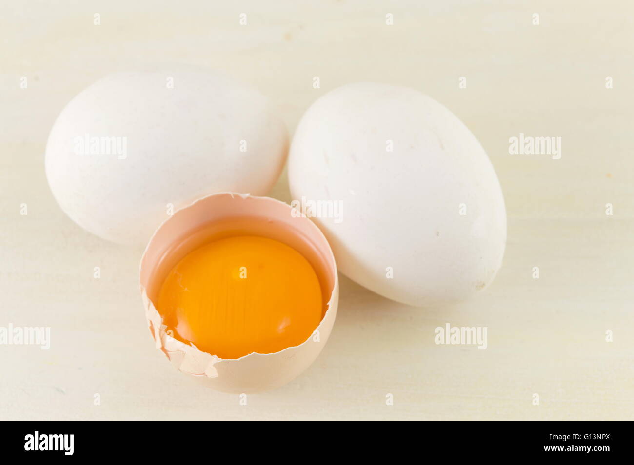 White fresh eggs with one broken one Stock Photo - Alamy