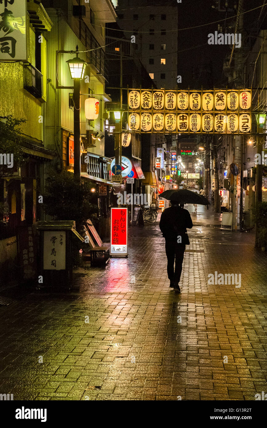A man walking in the rain in Tokyo at night Stock Photo - Alamy