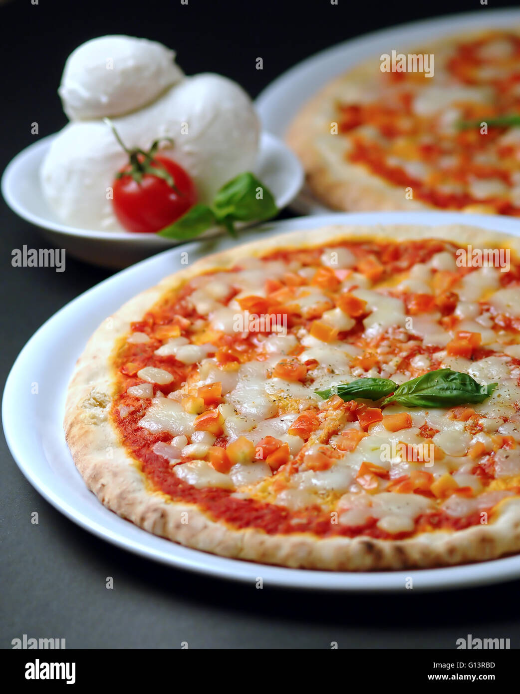 Tomato and mozzarella pizza on the table with fresh ingredients Stock ...