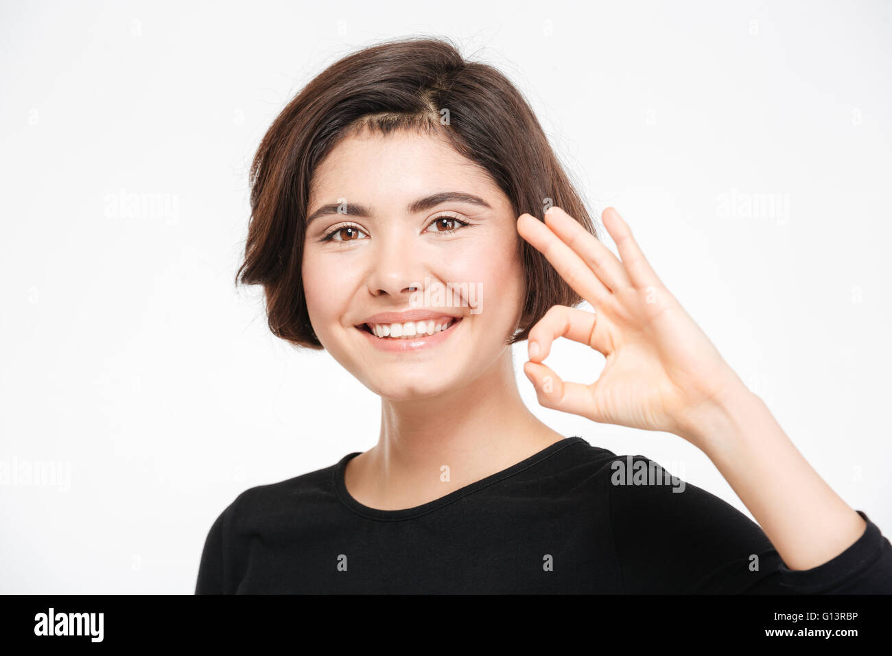 Smiling woman showing ok sign isolated on a white background Stock Photo - Alamy