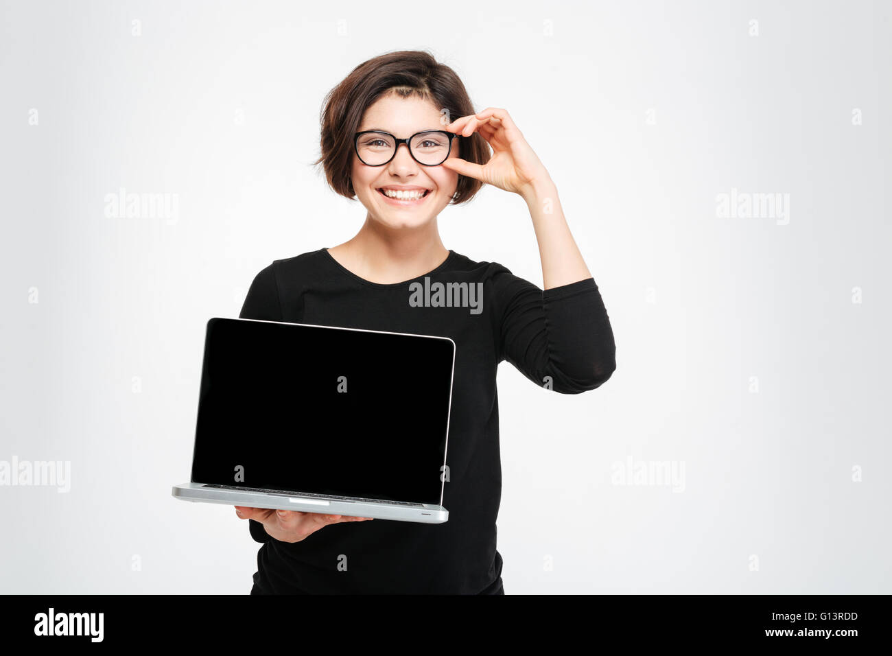 Smiling woman showing blank laptop computer screen isolated on a white ...