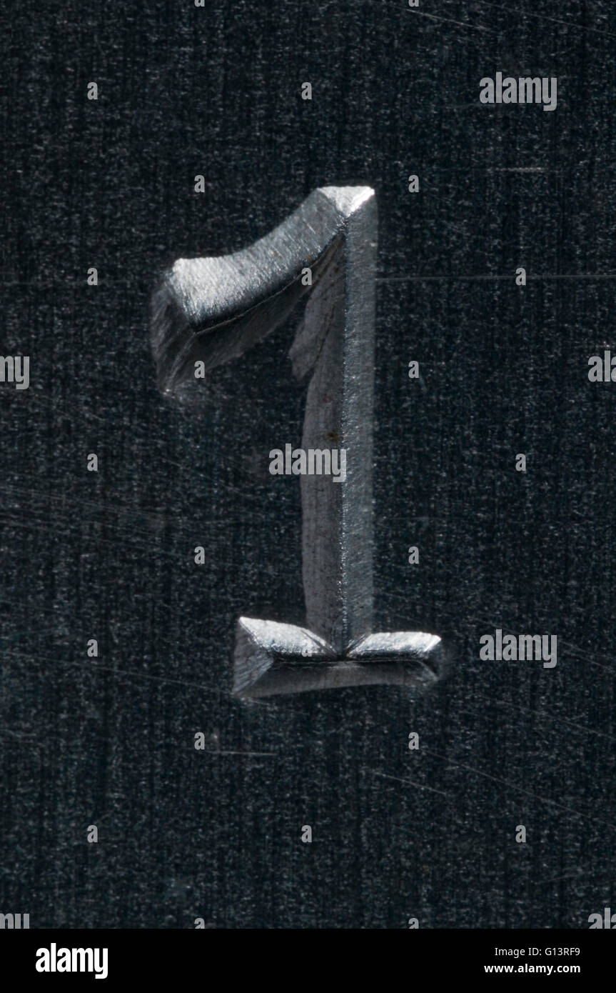 Macro view of a single letter "1" stamped in black metal Stock Photo ...