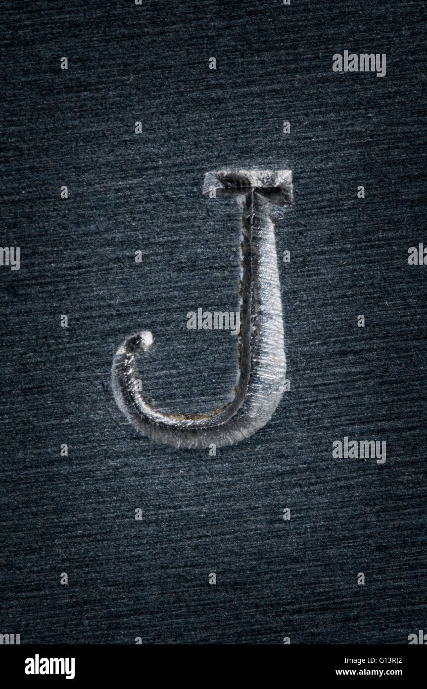 Macro view of a single letter "J" stamped in black metal Stock Photo ...