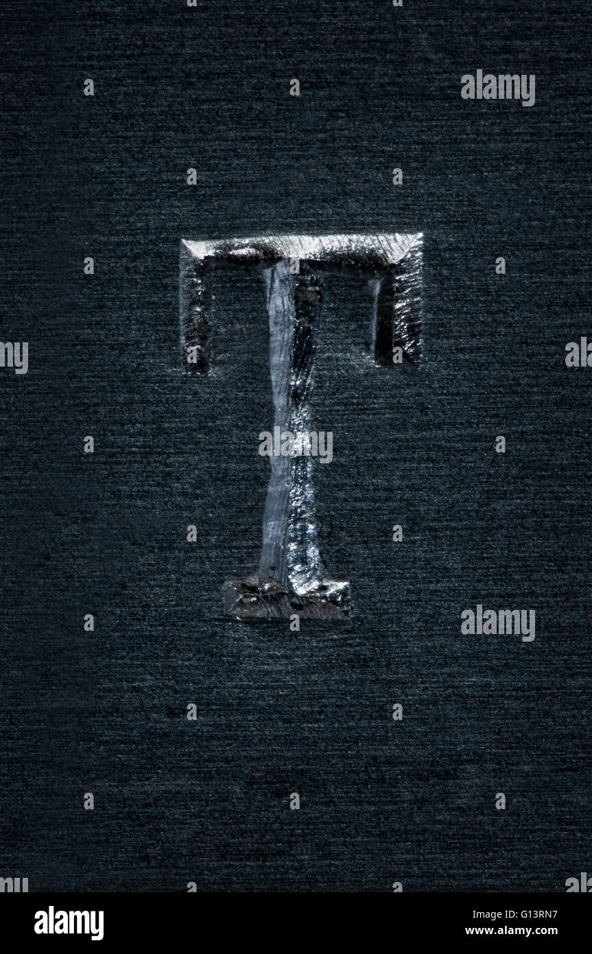 Macro view of a single letter "T" stamped in black metal Stock Photo ...