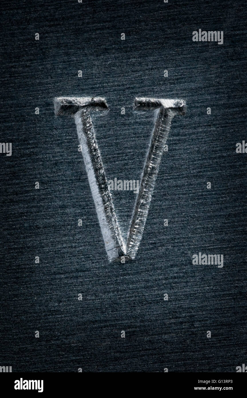 Macro view of a single letter "V" stamped in black metal Stock Photo ...