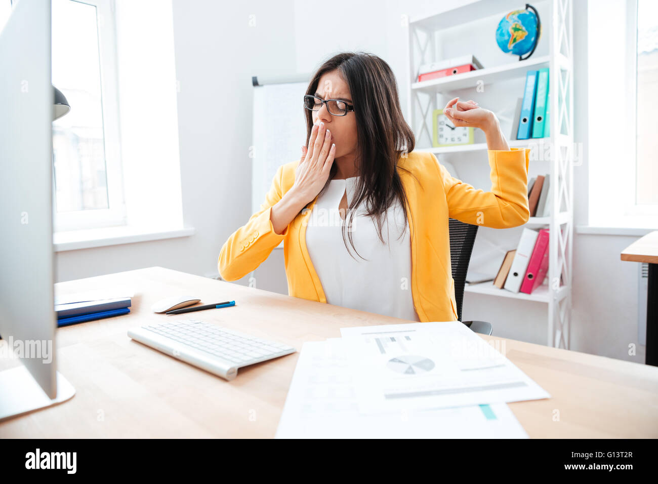 Young businesswoman yawning in office Stock Photo - Alamy