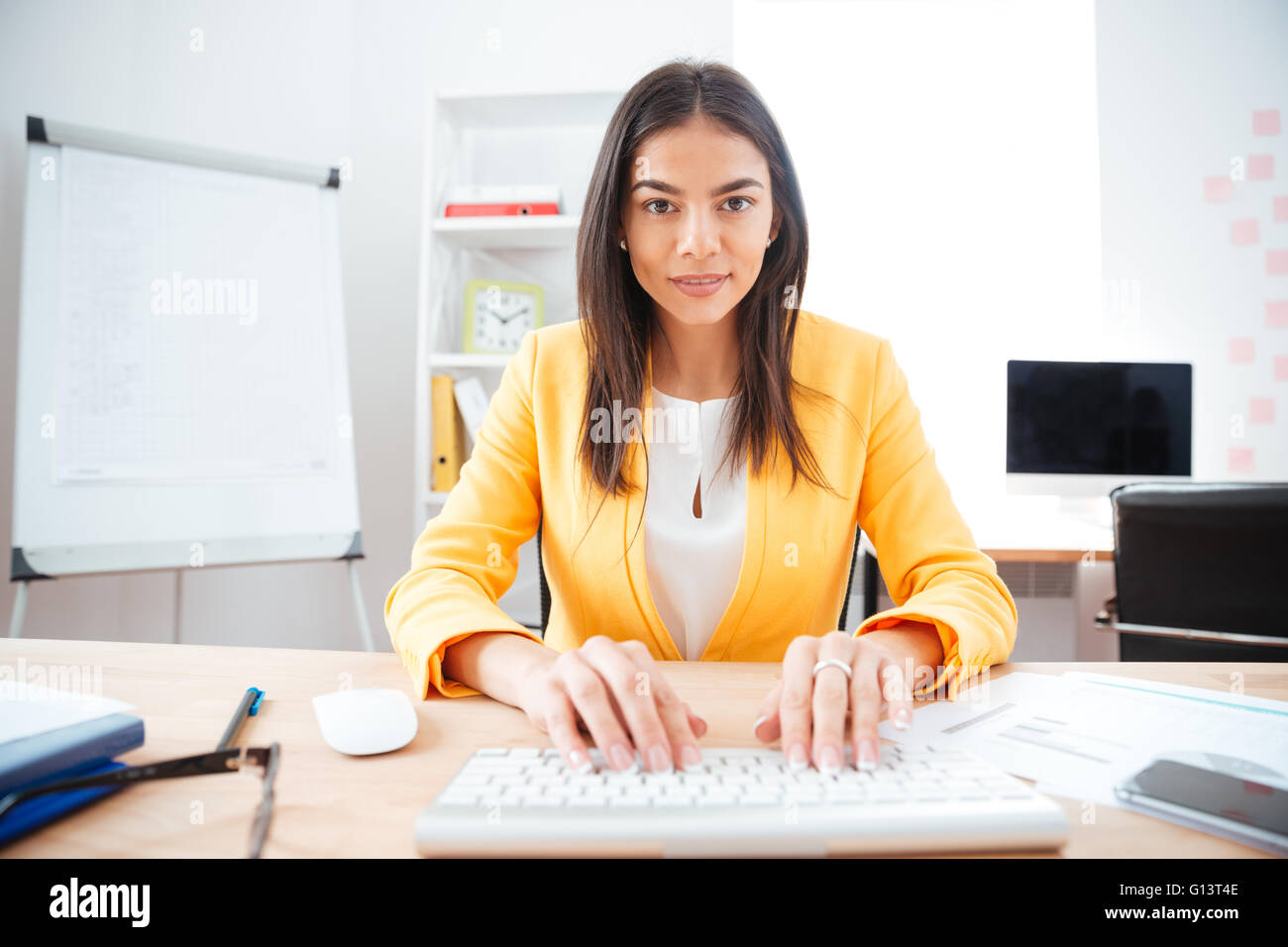 Happy charming businesswoman typing on keyboard in office Stock Photo ...