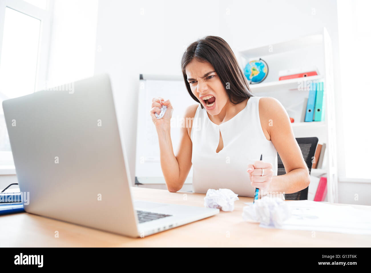 Angry businesswoman sitting at the table and screaming in office Stock ...