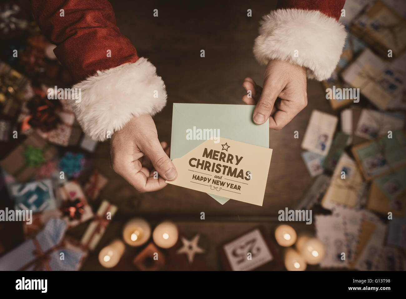 Santa claus opening an envelope and holding a christmas card hi-res ...