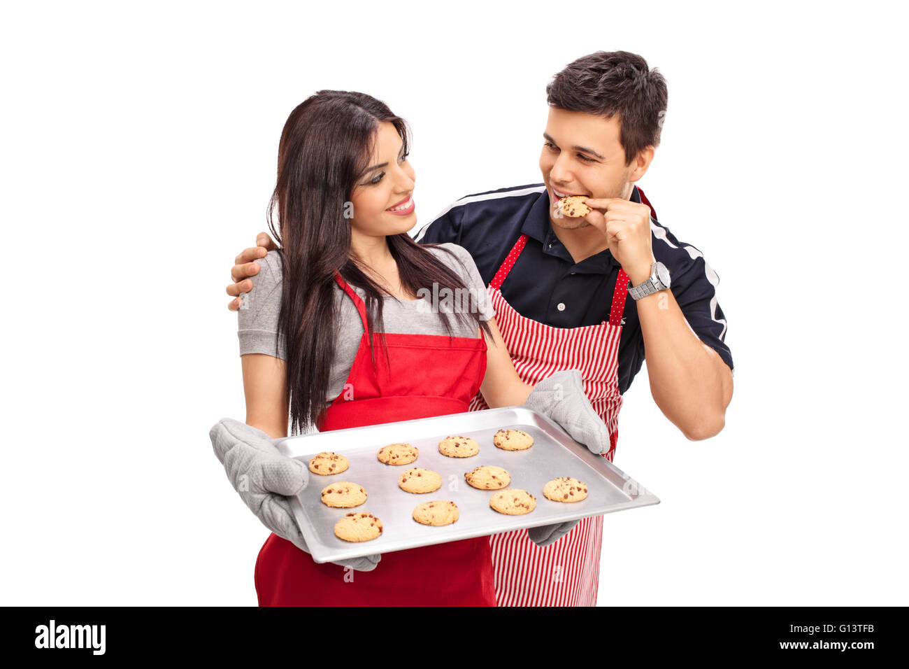 Young couple baking and eating cookies together isolated on white ...