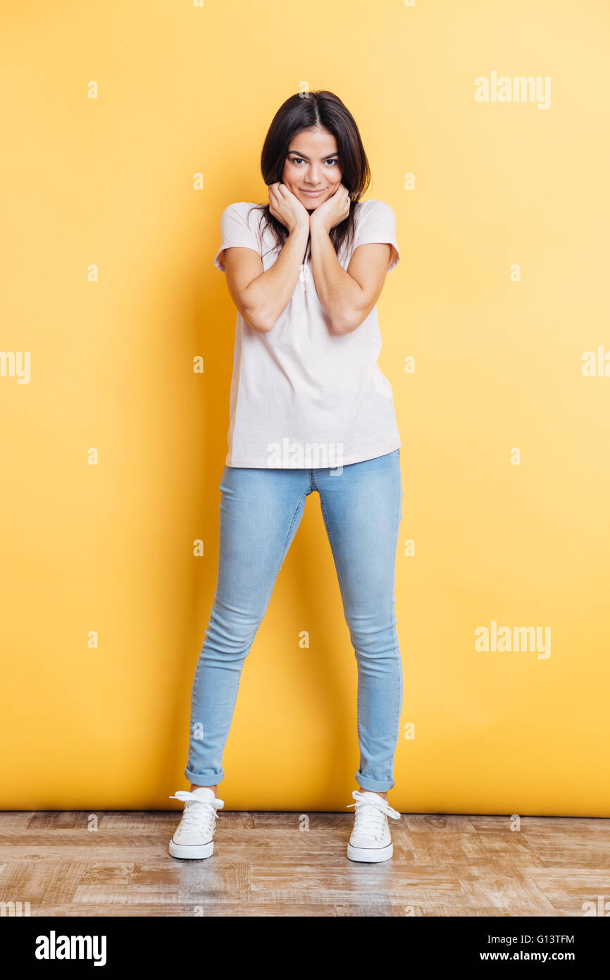 Full length portrait of a pretty woman posing on yellow background ...