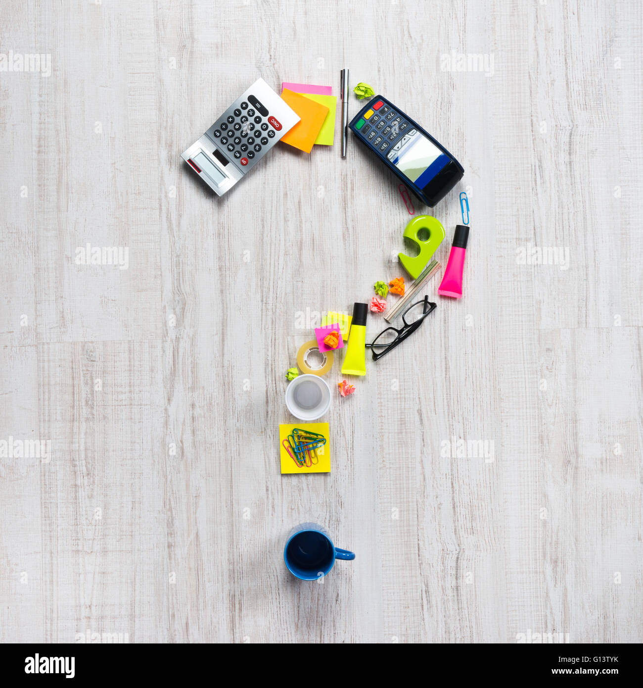 Question mark on the floor composed of stationery and office objects ...