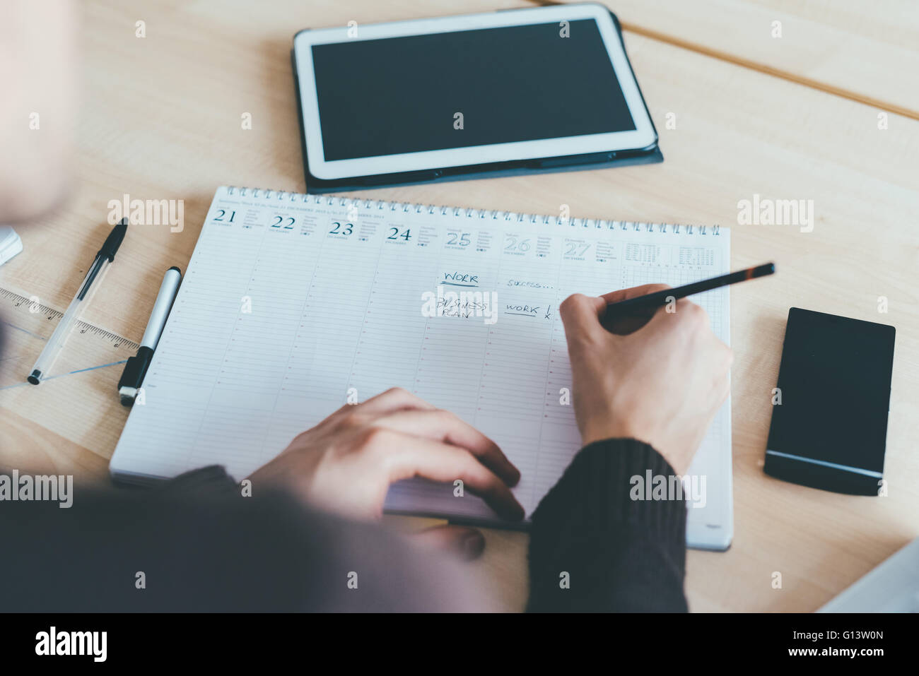 Top view close up hand of businessman writing on agenda with smart ...