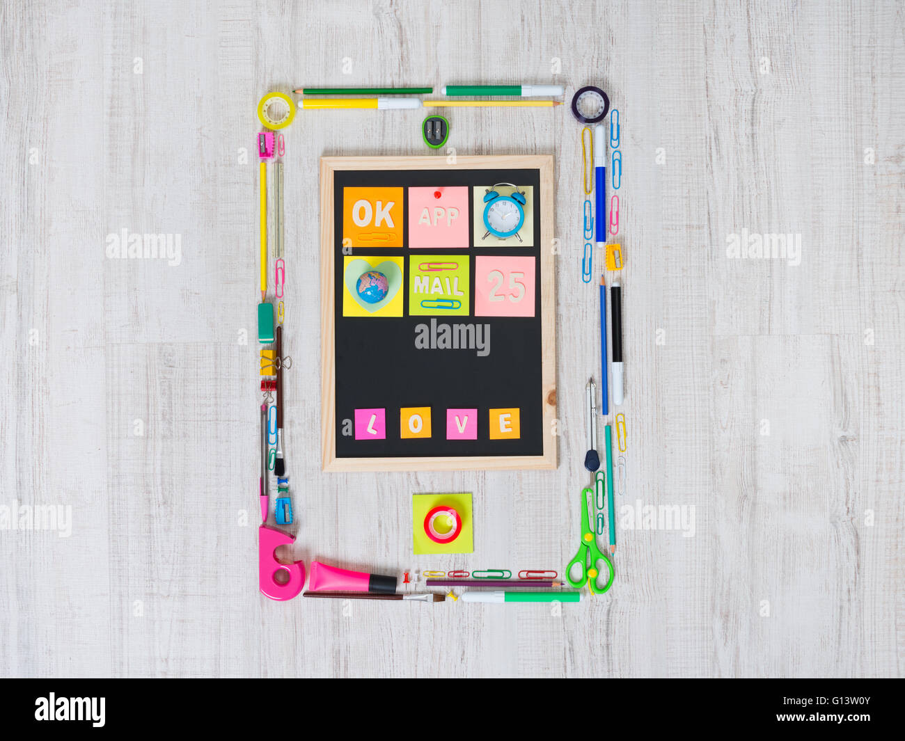 Creative smartphone composed of colorful stationery items on the floor ...